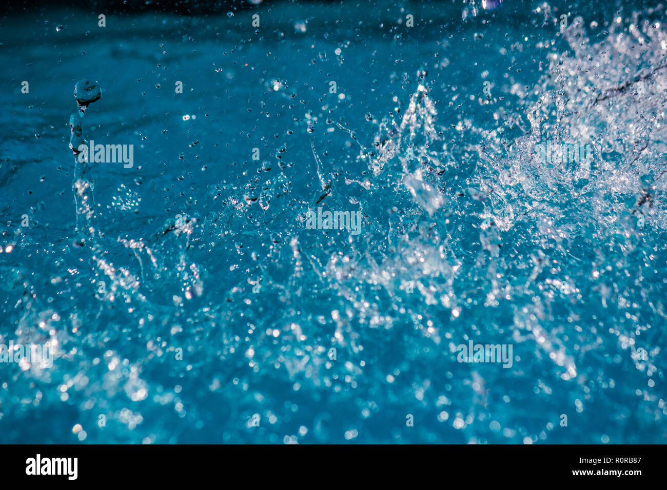 Closeup of a splash taking place over the surface of a crystal clear ...