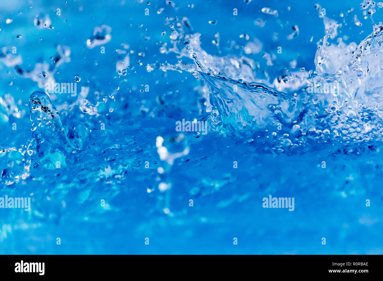 Closeup of a splash taking place over the surface of a crystal clear ...