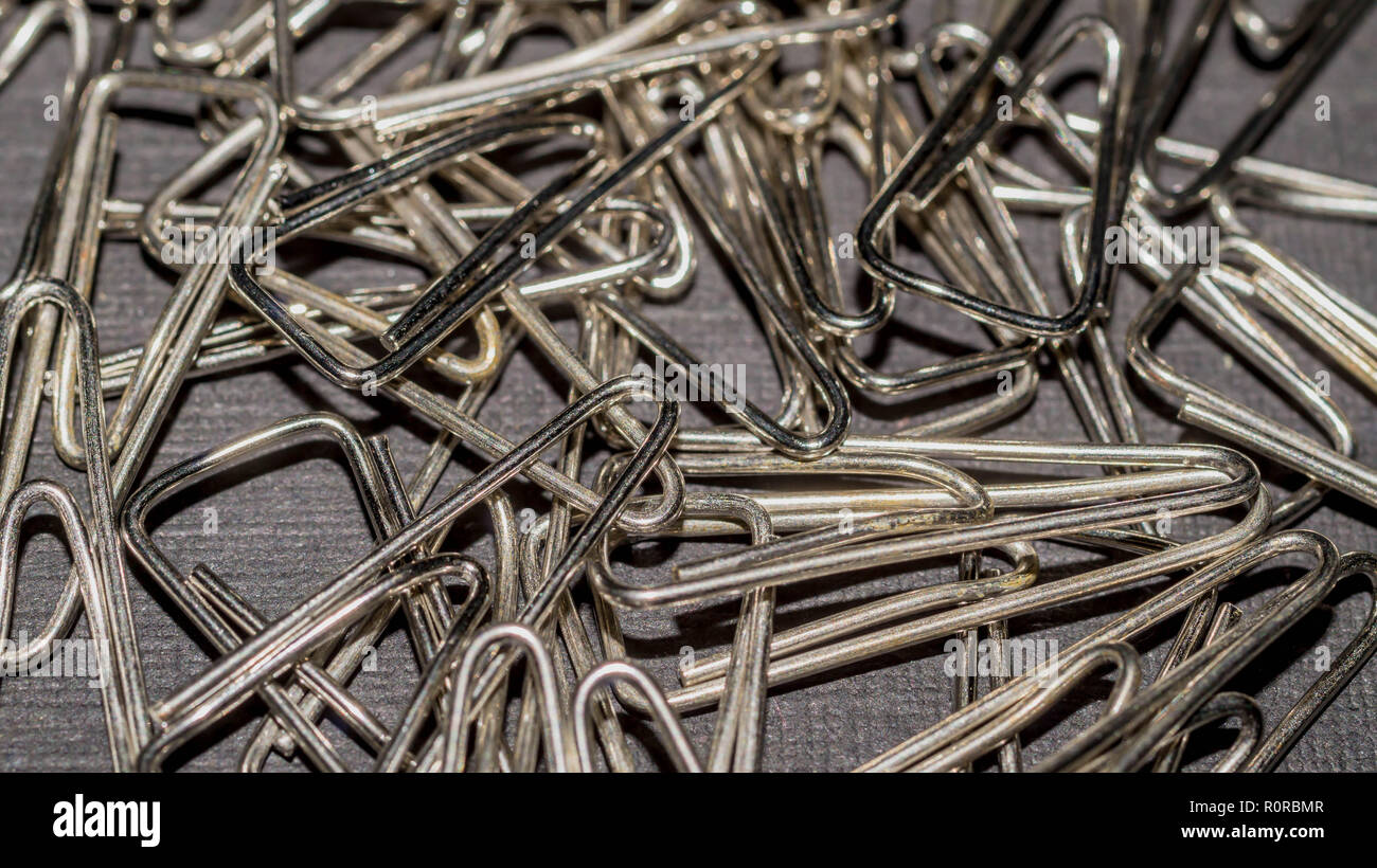 metallic triangular paper clip. office and school supply background ...
