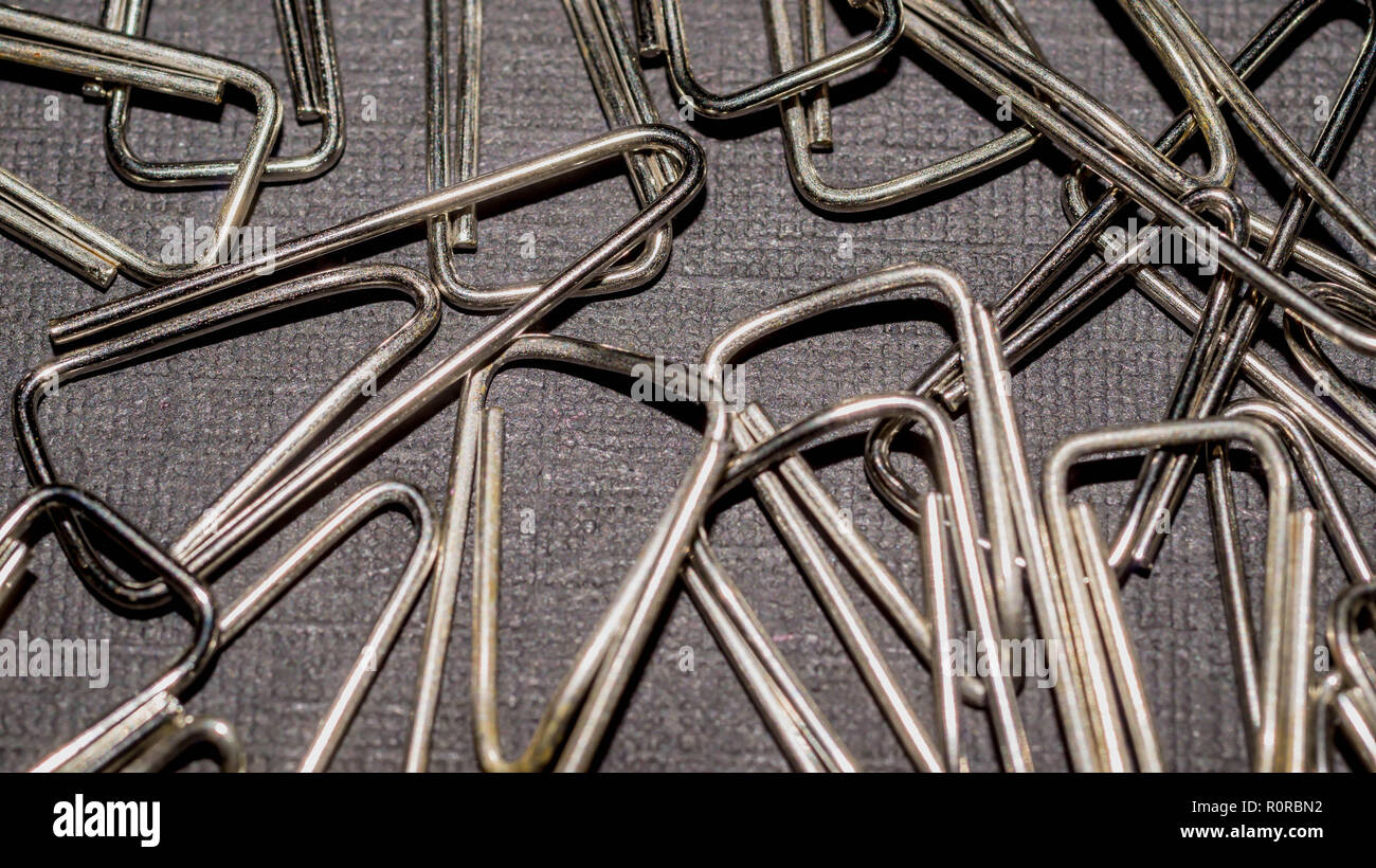 metallic triangular paper clip. office and school supply background ...