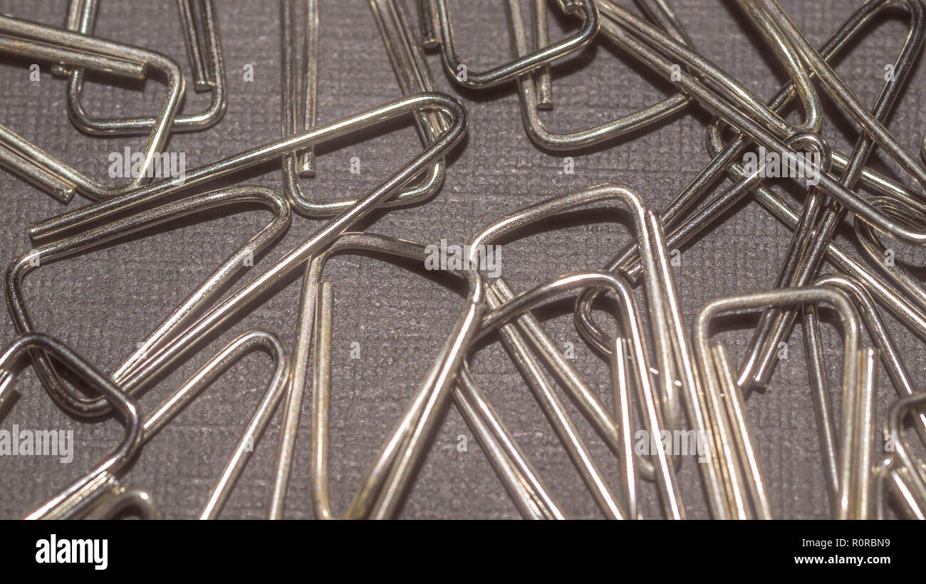 metallic triangular paper clip. office and school supply background ...