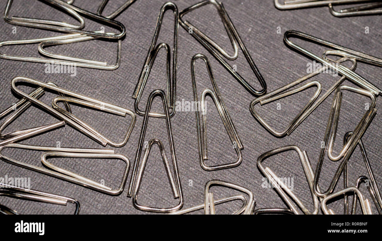 metallic triangular paper clip. office and school supply background ...