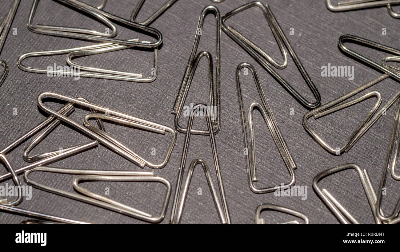metallic triangular paper clip. office and school supply background ...