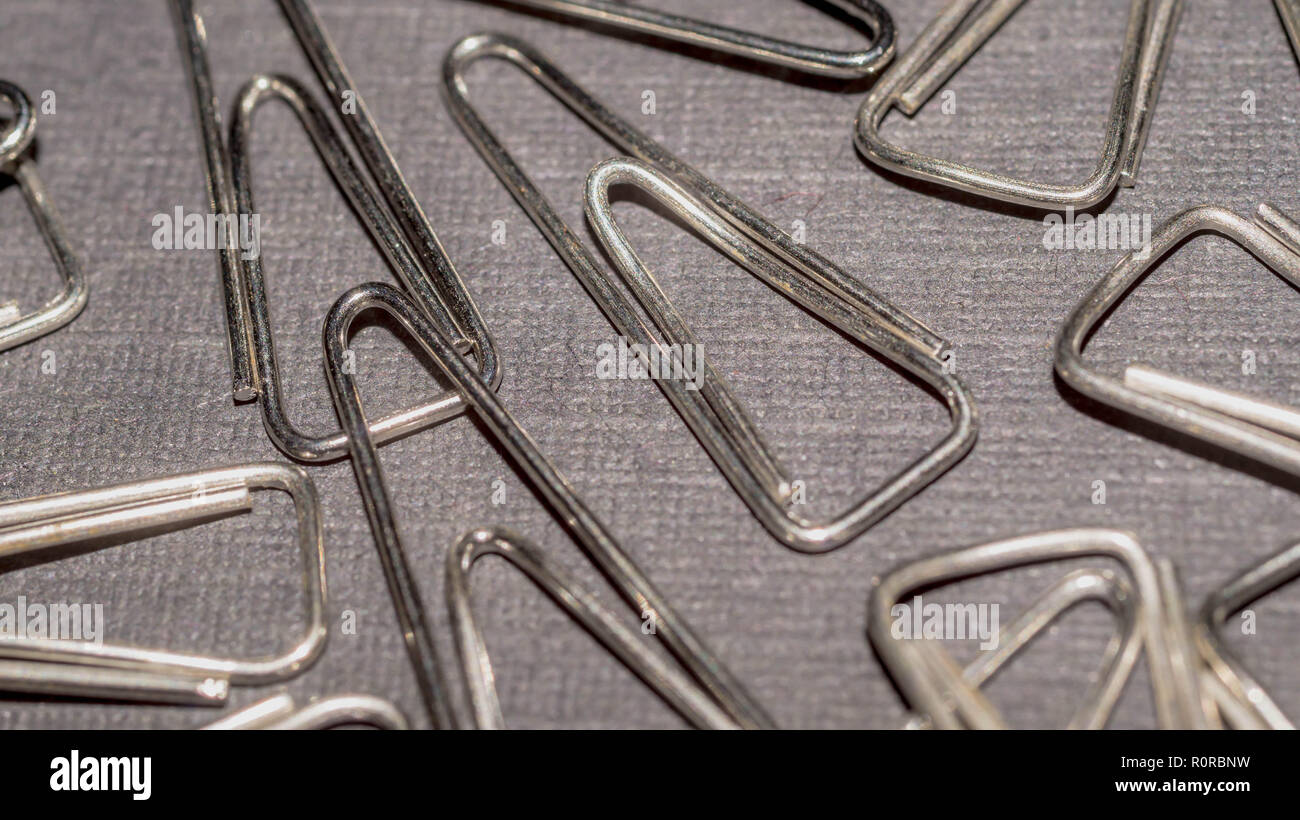 metallic triangular paper clip. office and school supply background ...