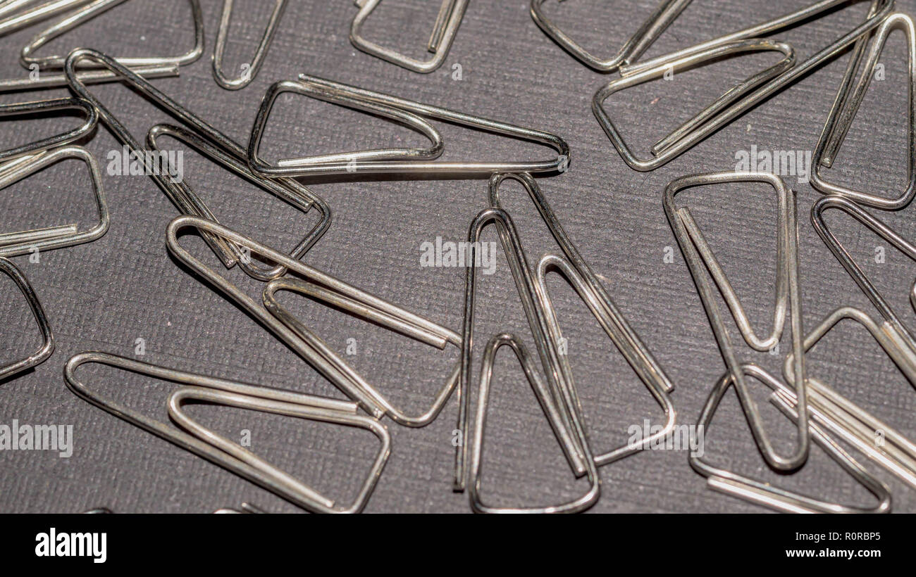 metallic triangular paper clip. office and school supply background ...