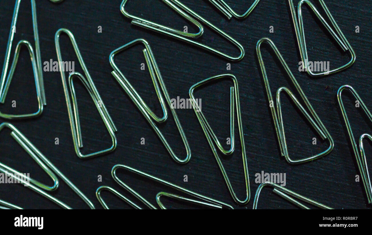 metallic triangular paper clip. office and school supply background ...