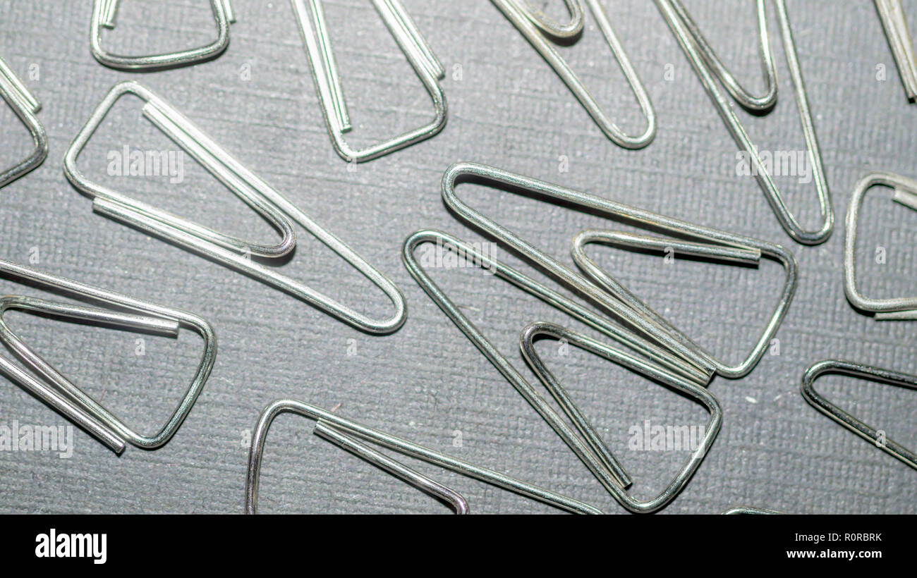 metallic triangular paper clip. office and school supply background ...