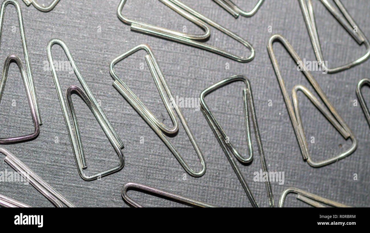 metallic triangular paper clip. office and school supply background ...