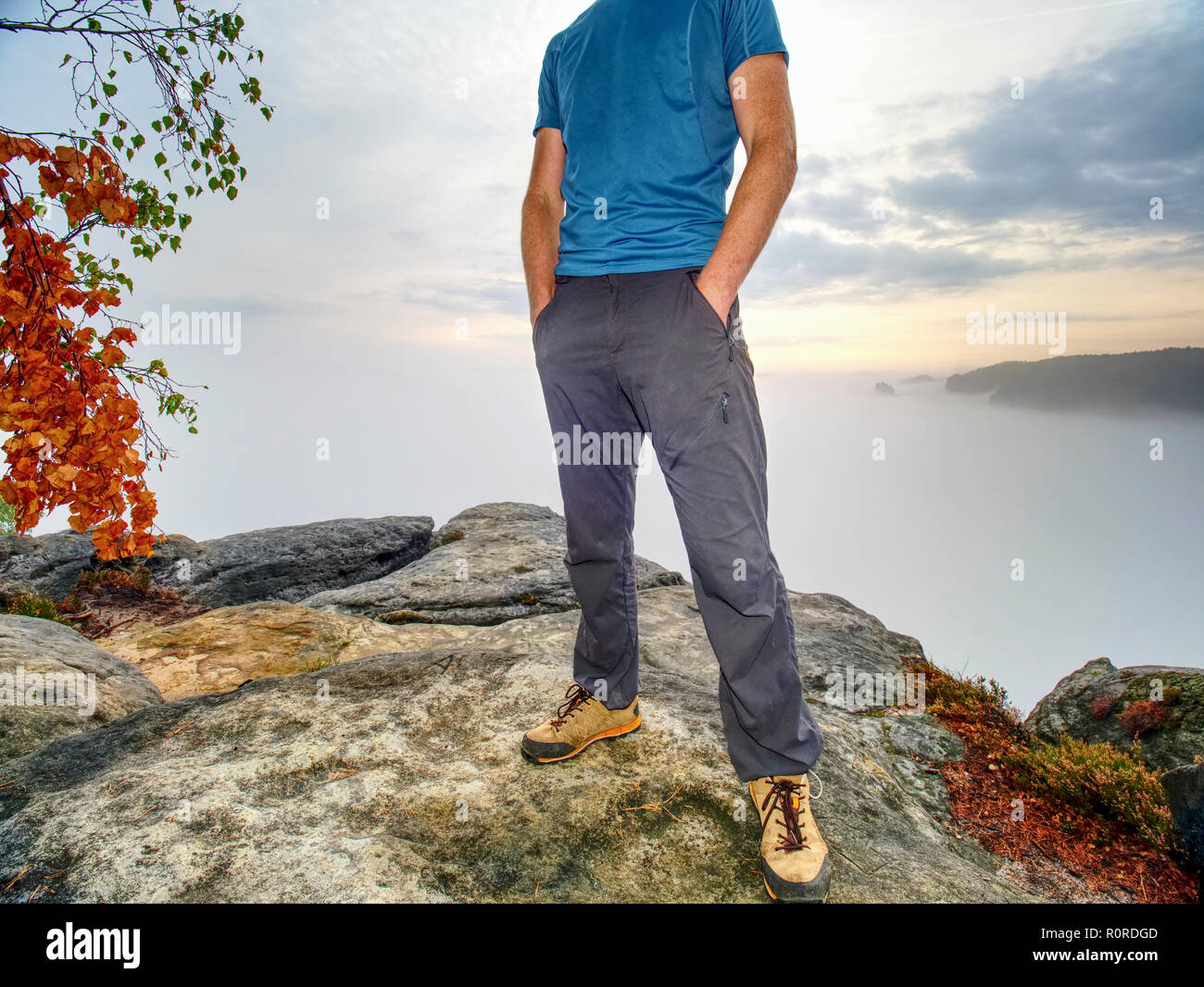 Tall guy with hands in pocket in blue shirt standing and watch the ...