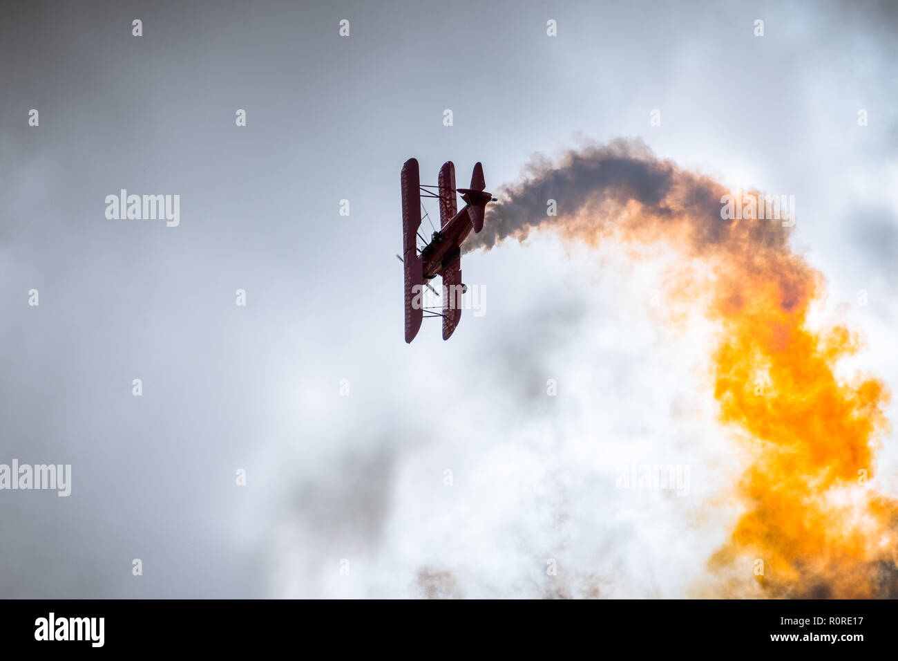 Old airplane performing flying tricks and leaving behind a trail of ...