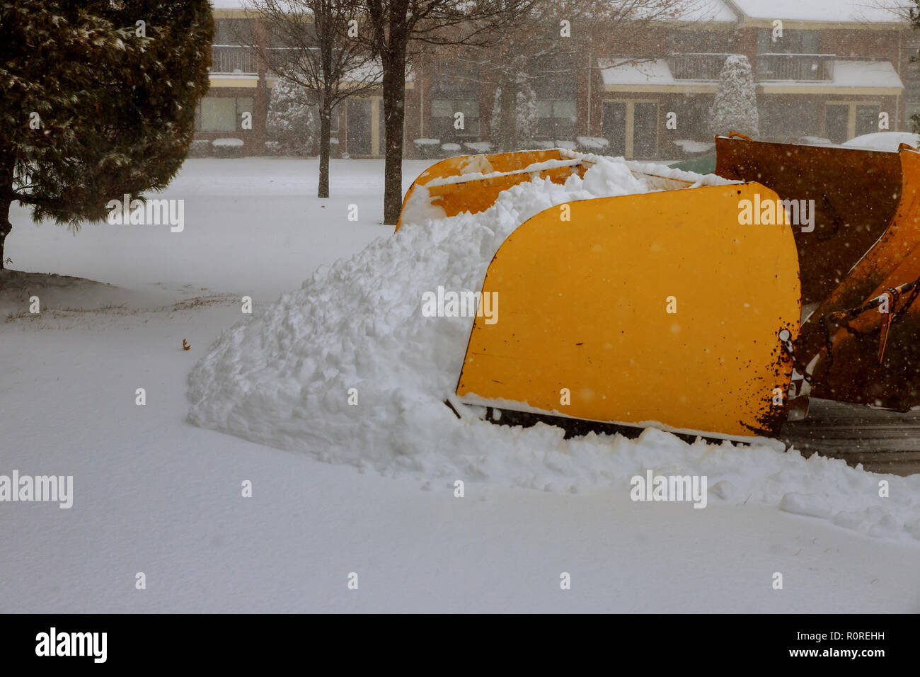 snow sweeper works on the snowy street with backhoe removes snow from ...