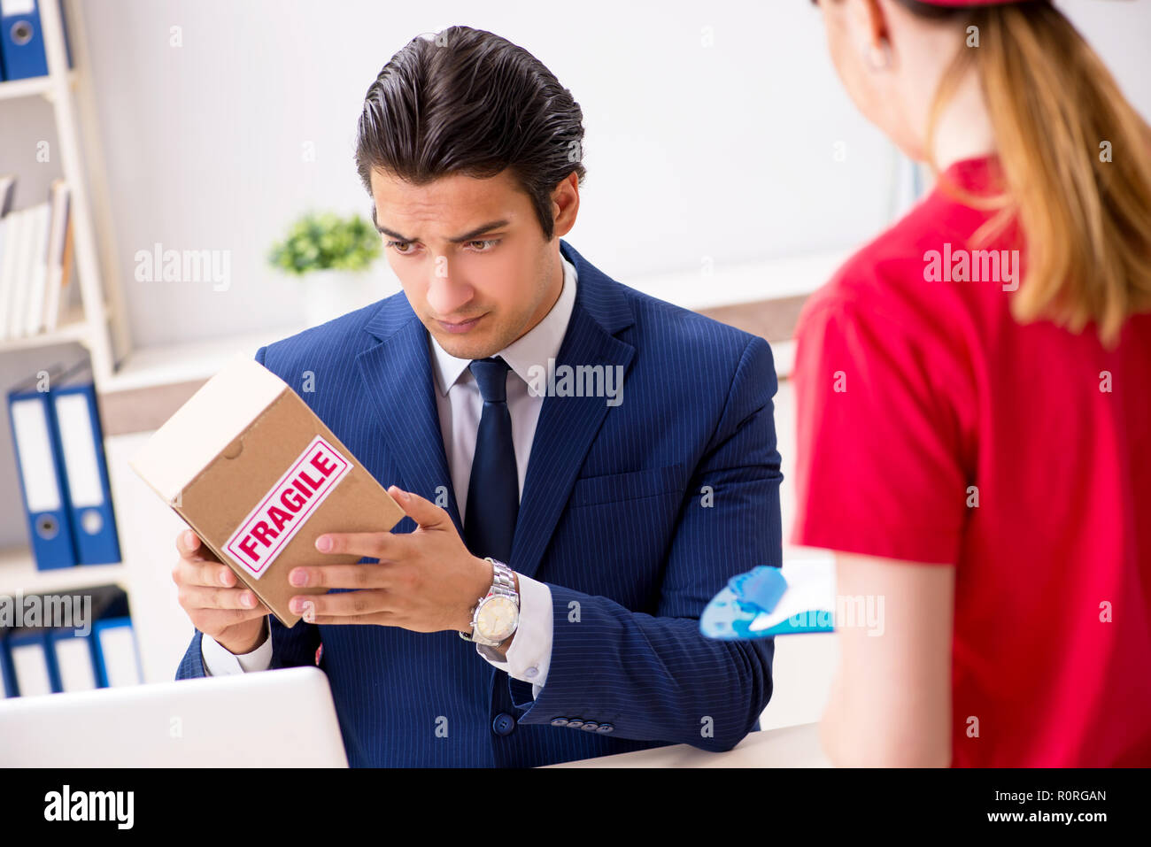 Courier delivering parcel to the office Stock Photo - Alamy