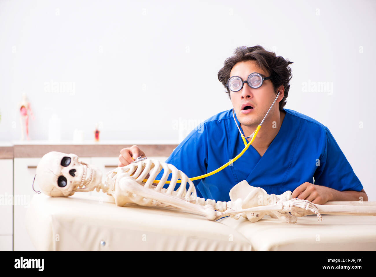 Funny doctor with skeleton in hospital Stock Photo - Alamy