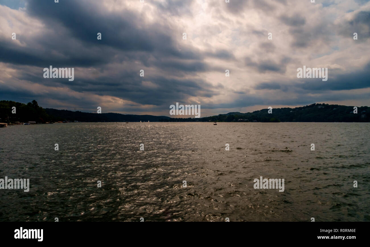 Moody stormy cloudy lake landscape with mountains in background summer ...