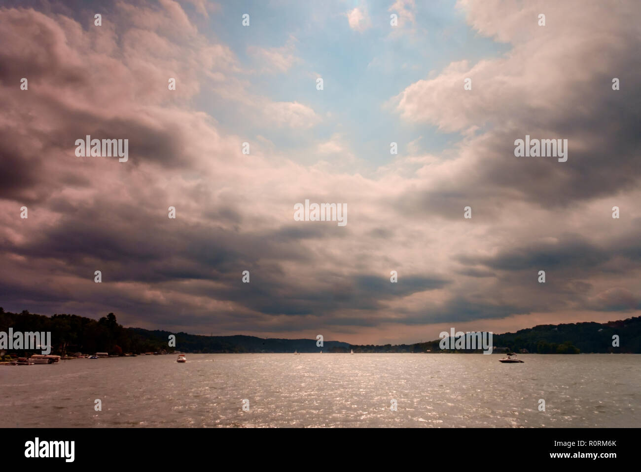 Moody stormy cloudy lake landscape with mountains in background summer ...