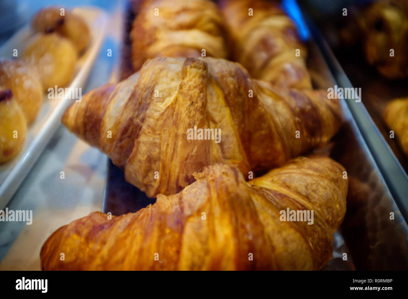 French croissants on display at local bakery in glass case Stock Photo ...
