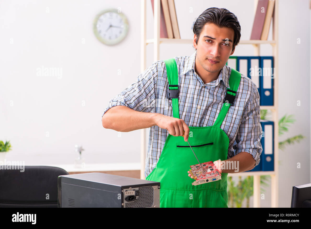 Young engineer repairing broken computer at the office Stock Photo - Alamy