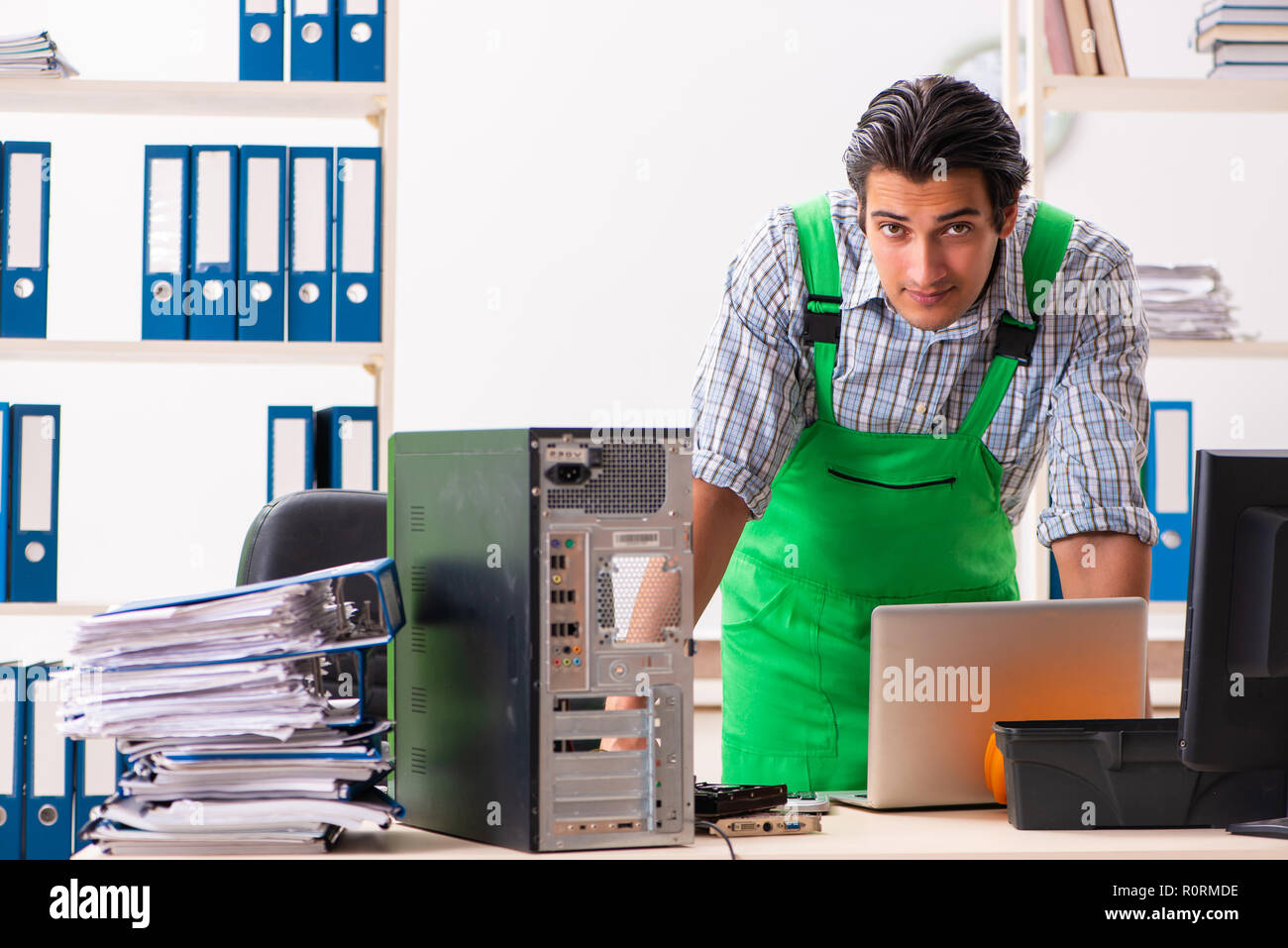 Young engineer repairing broken computer at the office Stock Photo - Alamy