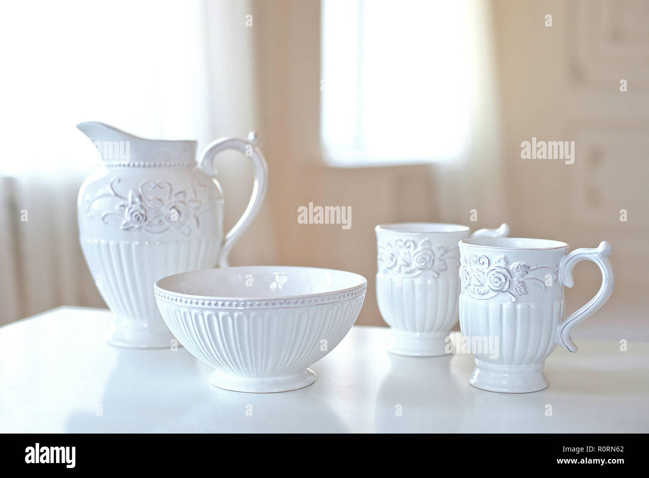 Set of white ceramic kitchen utensils, dishes on white table in big ...