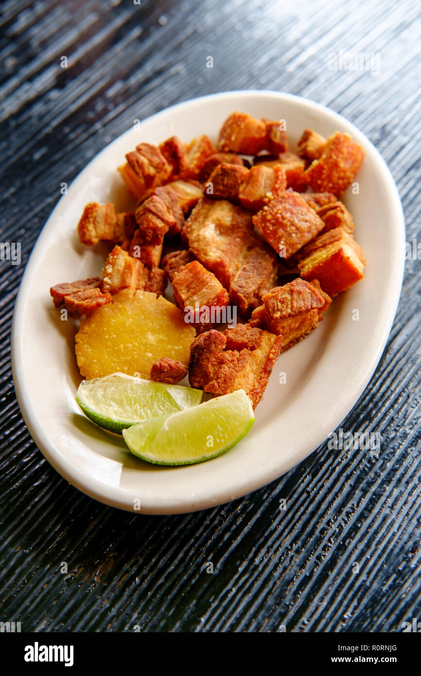 Colombian fried pork belly, chicharrón colombiano, with sliced limes ...