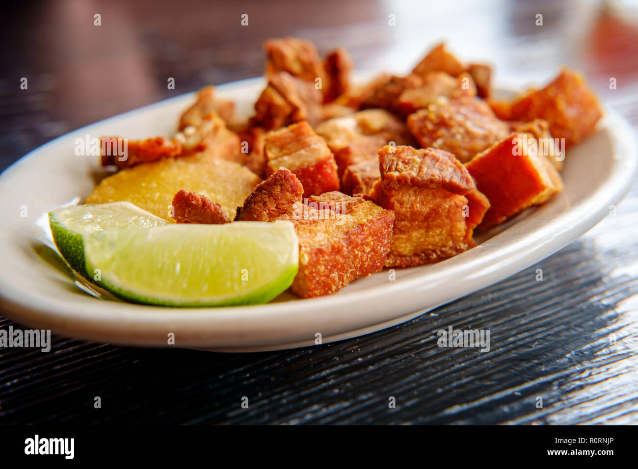 Colombian fried pork belly, chicharrón colombiano, with sliced limes ...
