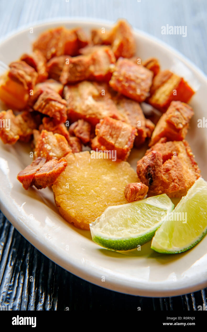 Colombian fried pork belly, chicharrón colombiano, with sliced limes ...