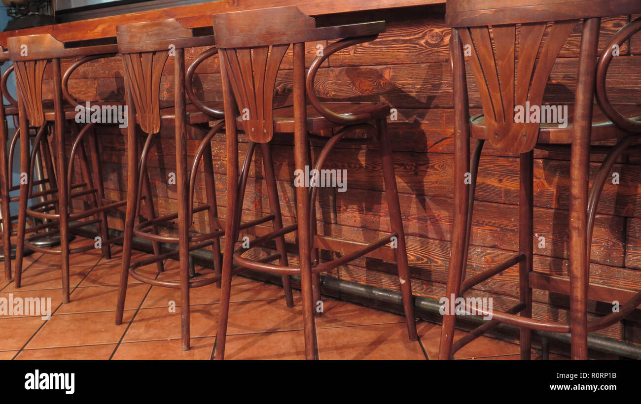 Row of wooden bar stools in empty restauant in Granada jewish quarter ...