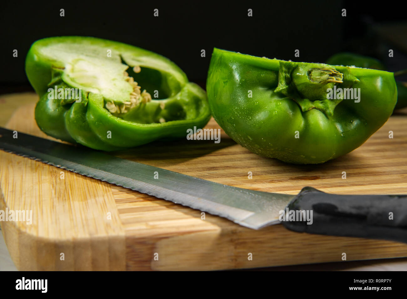 Green bell pepper sliced in half showing seeds and pith Stock Photo - Alamy