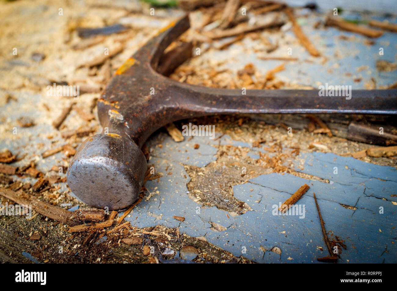Old and worn contracting hammer and three nails on a distressed work ...