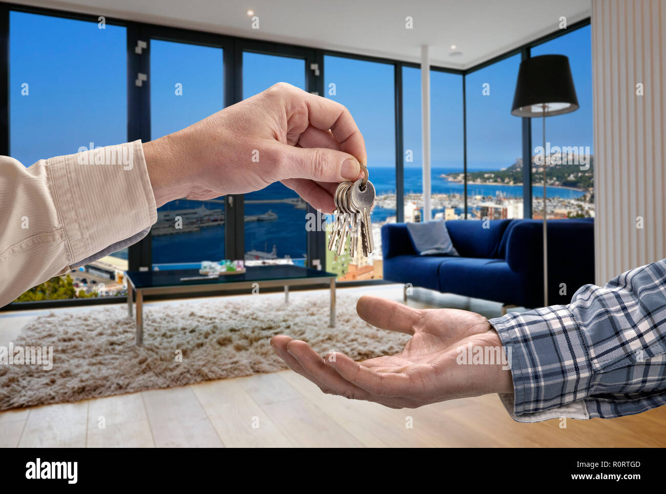 Realtor giving house key to buyer in Modern living room with large ...