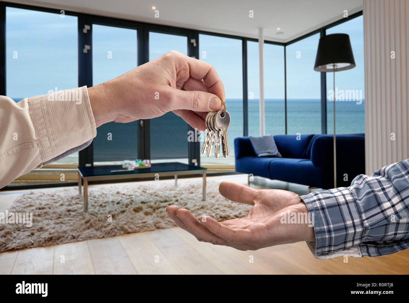 Realtor giving house key to buyer in Modern living room with large ...