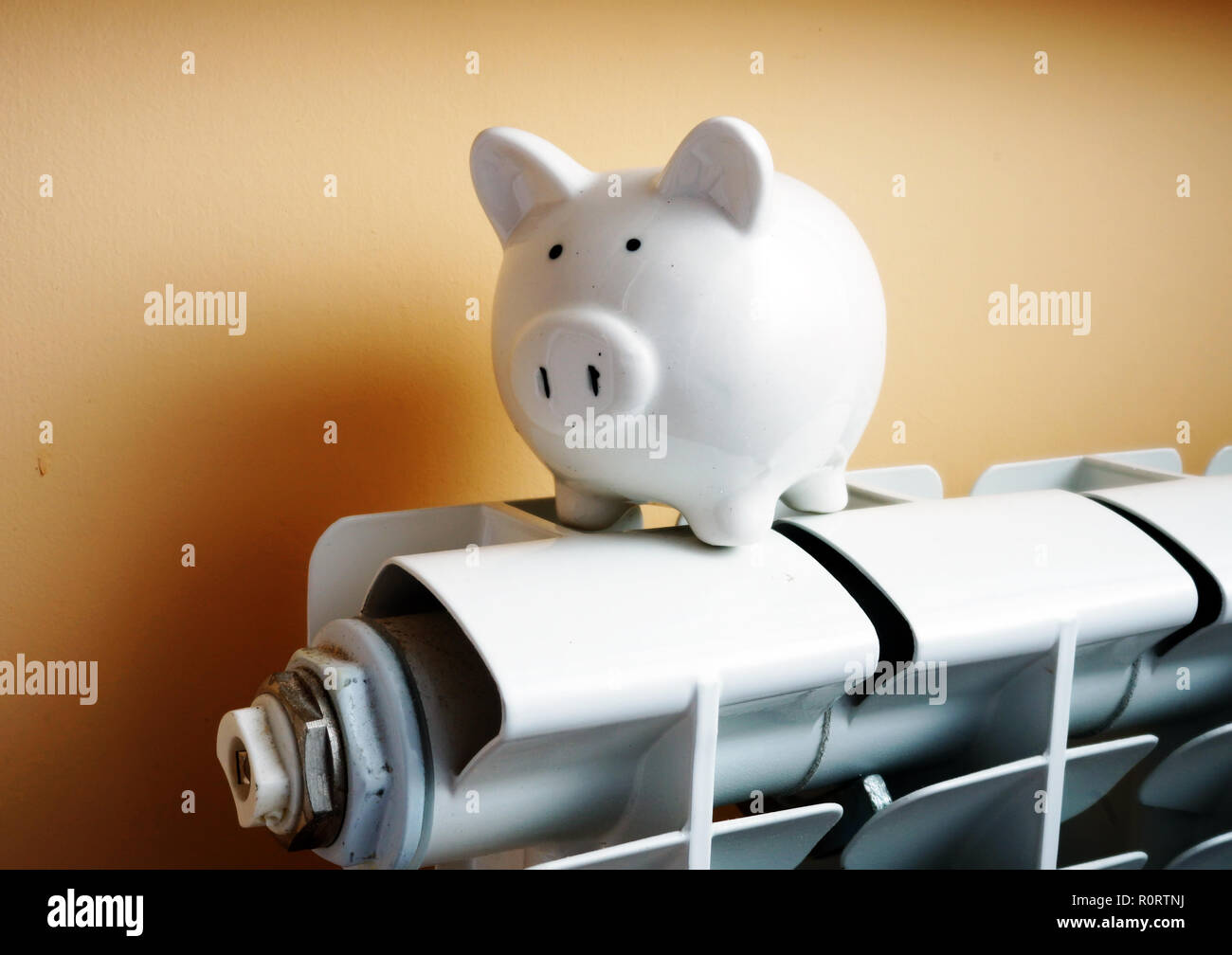 Heating radiator and piggy bank on it. Savings concept Stock Photo - Alamy