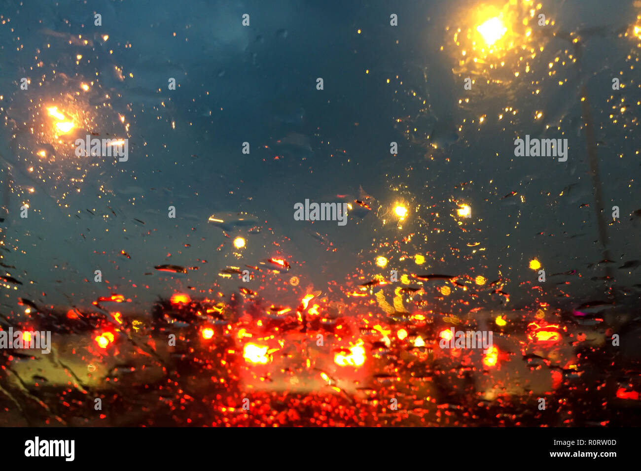 Driving in the rain. Water drops on front glass of the car while ...