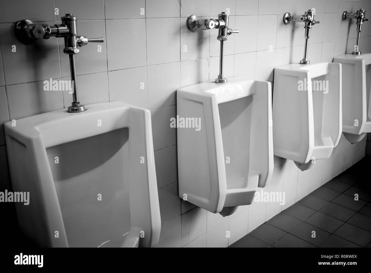 Old white ceramic urinals in men's bathroom. Toilet in restroom Stock ...