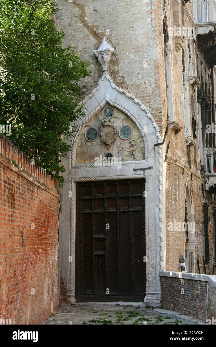 Venice, door of an ancient palace, with marble decorations and a brick ...