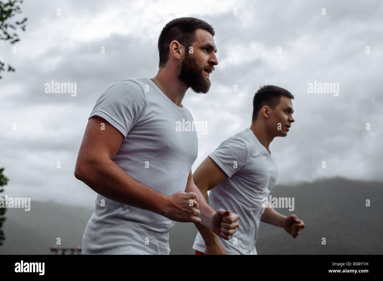 Morning workout, sportive men running in mountains living healthy ...