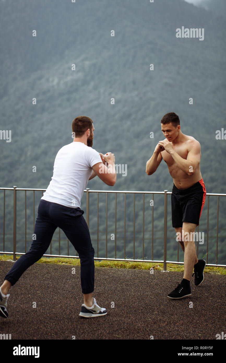 Two athletes rest after intense outdoor workout training in mountain ...