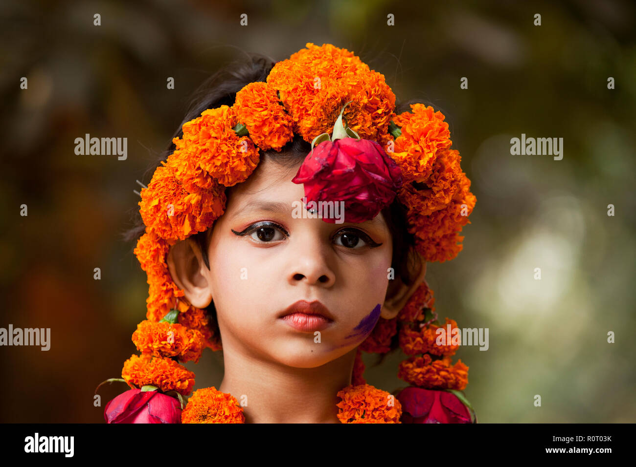 A little girl wears yellow saree and decorates her hair with flowers on ...