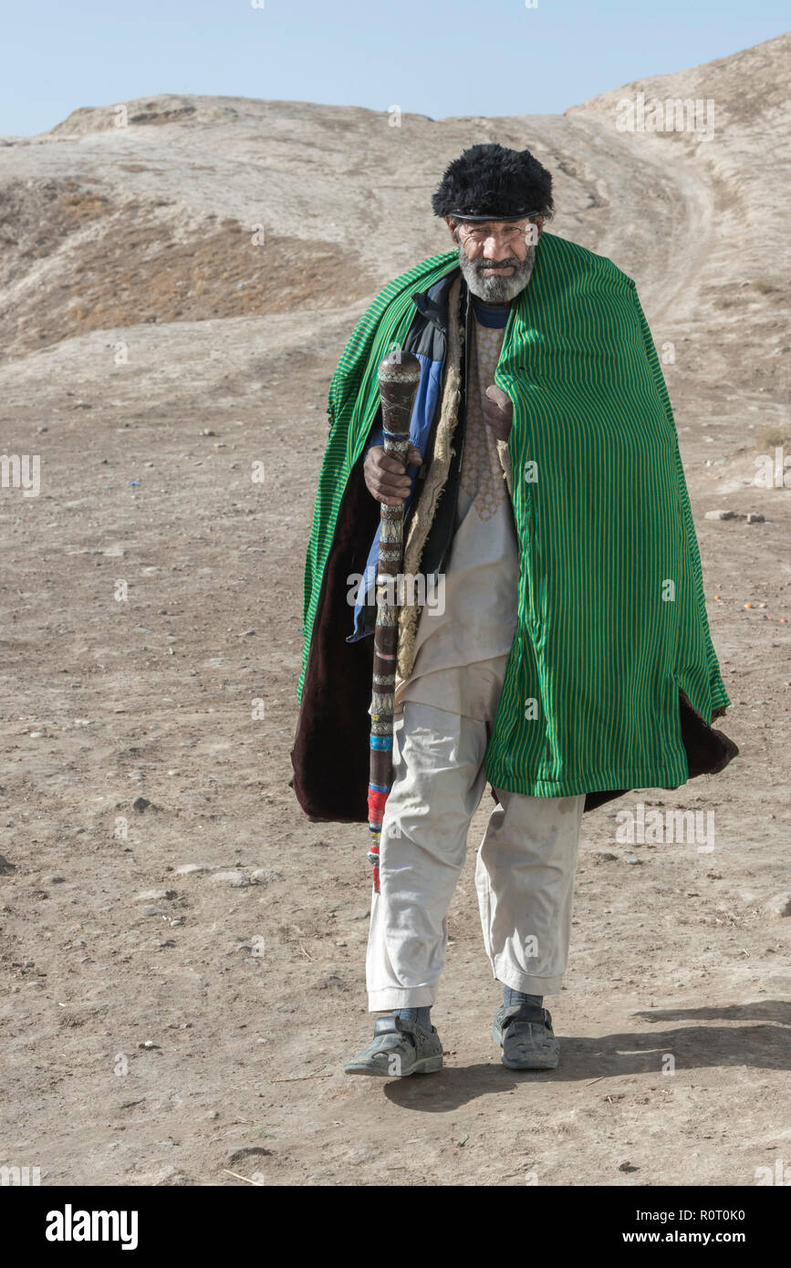 Old Sufi Man Wearing Green Coat Walking In The Desert With Stick ...