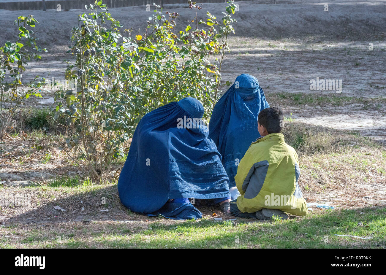 Two Women Wearing Traditional Blue Burqa Relaxing With A Child Wearing ...