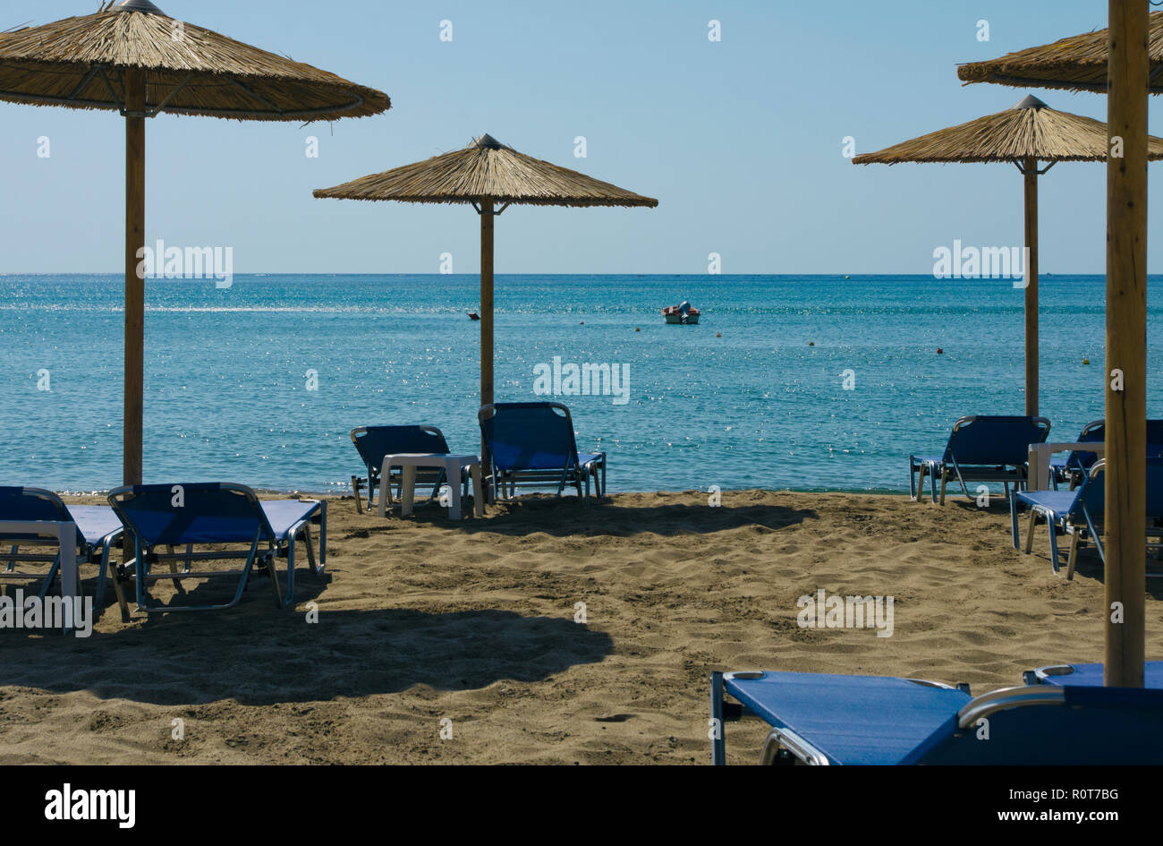 Mediterranean landscape with beach umbrellas and sunbeds in the ...