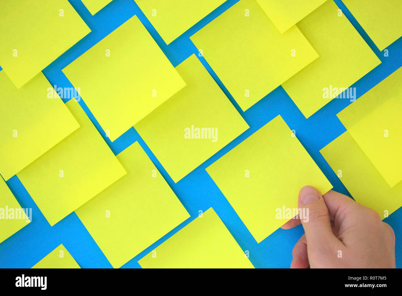 Hand holding post-it note on blue board Stock Photo - Alamy