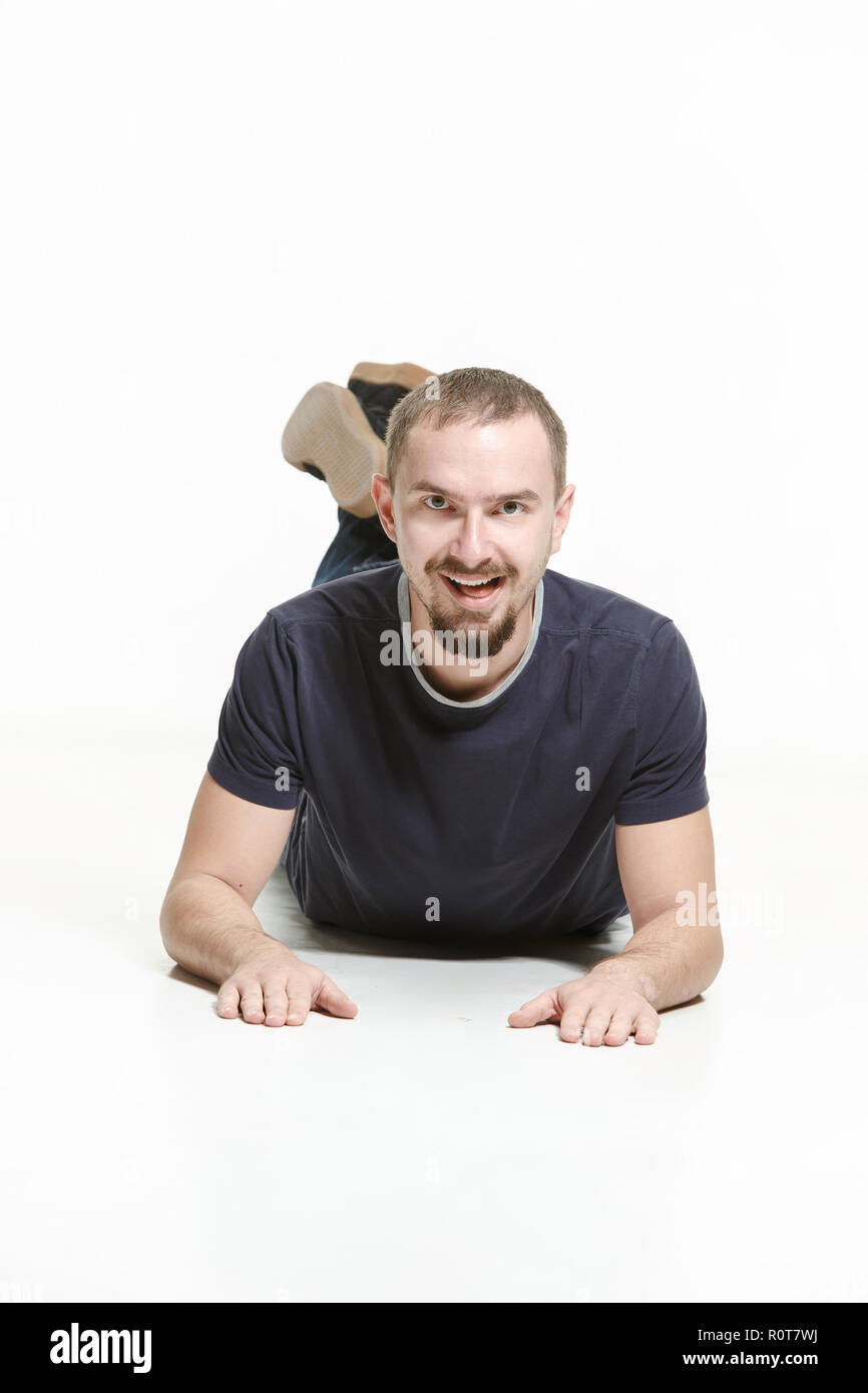 The smiling man lying on floor at white studio Stock Photo - Alamy