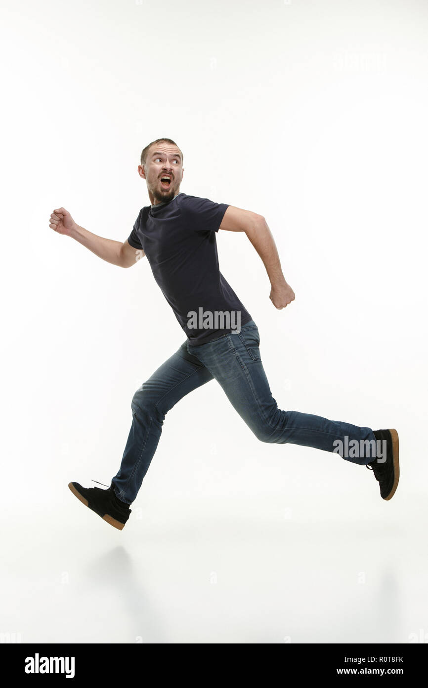 Man running fast at white studio background Stock Photo - Alamy