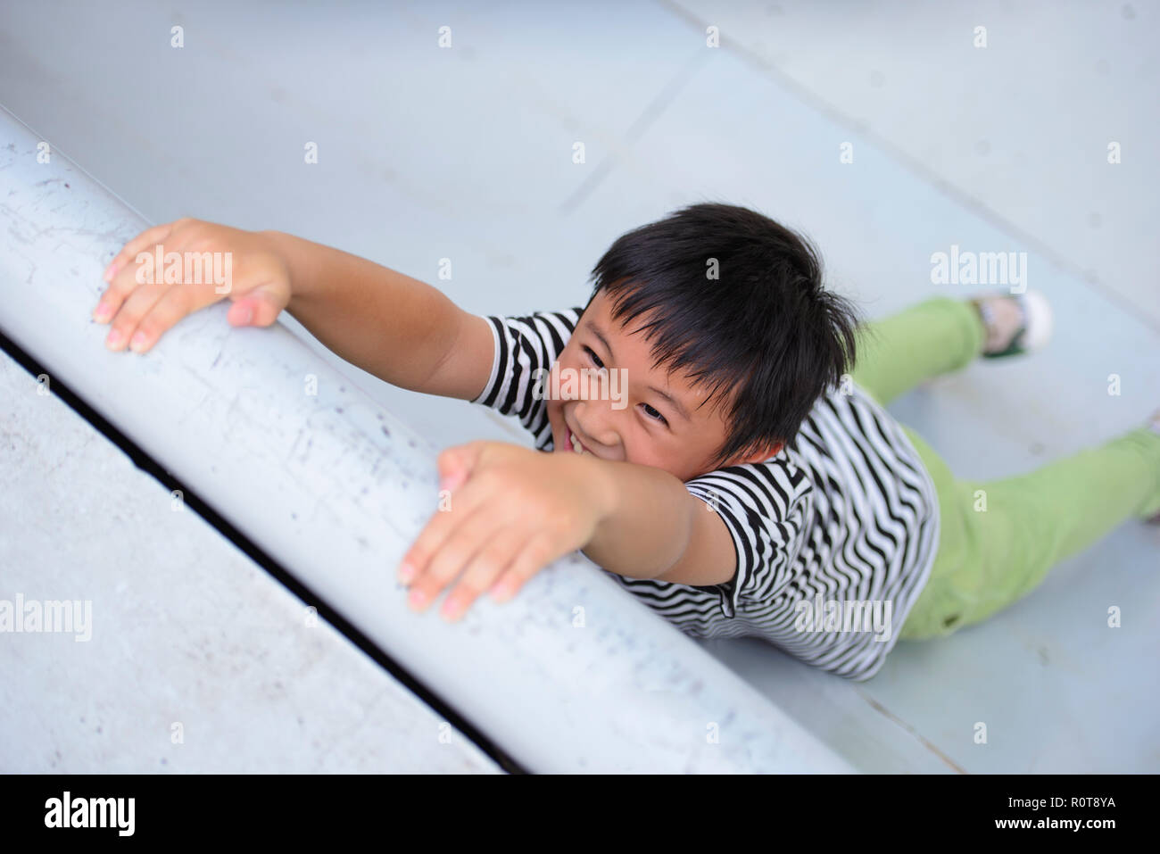 Little boy hanging on wall on hands and trying to climb up Stock Photo ...