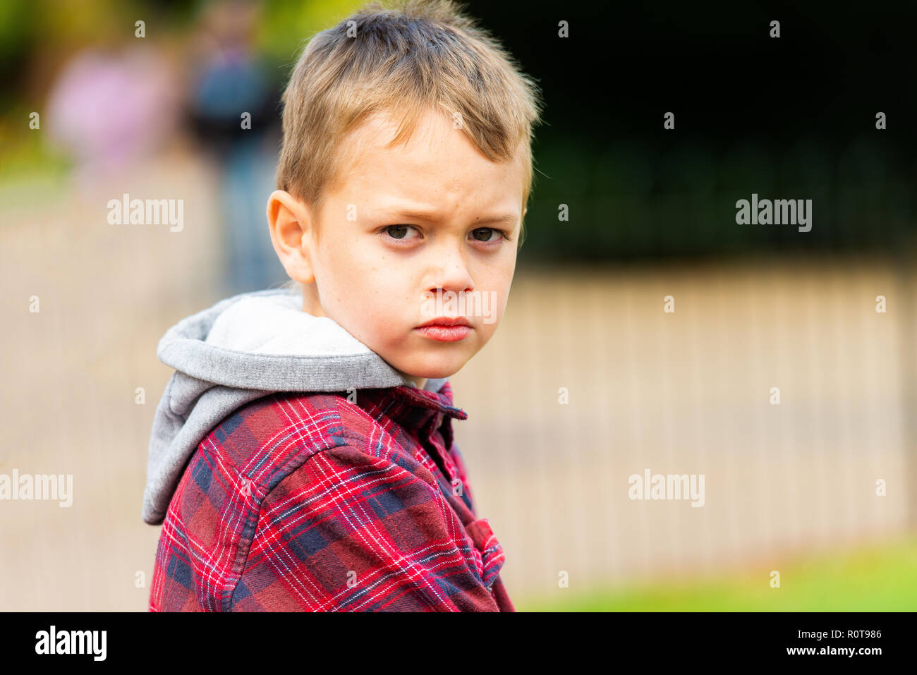 A handsome boy with ADHD, Autism, Asperger Syndrome sitting at the park ...
