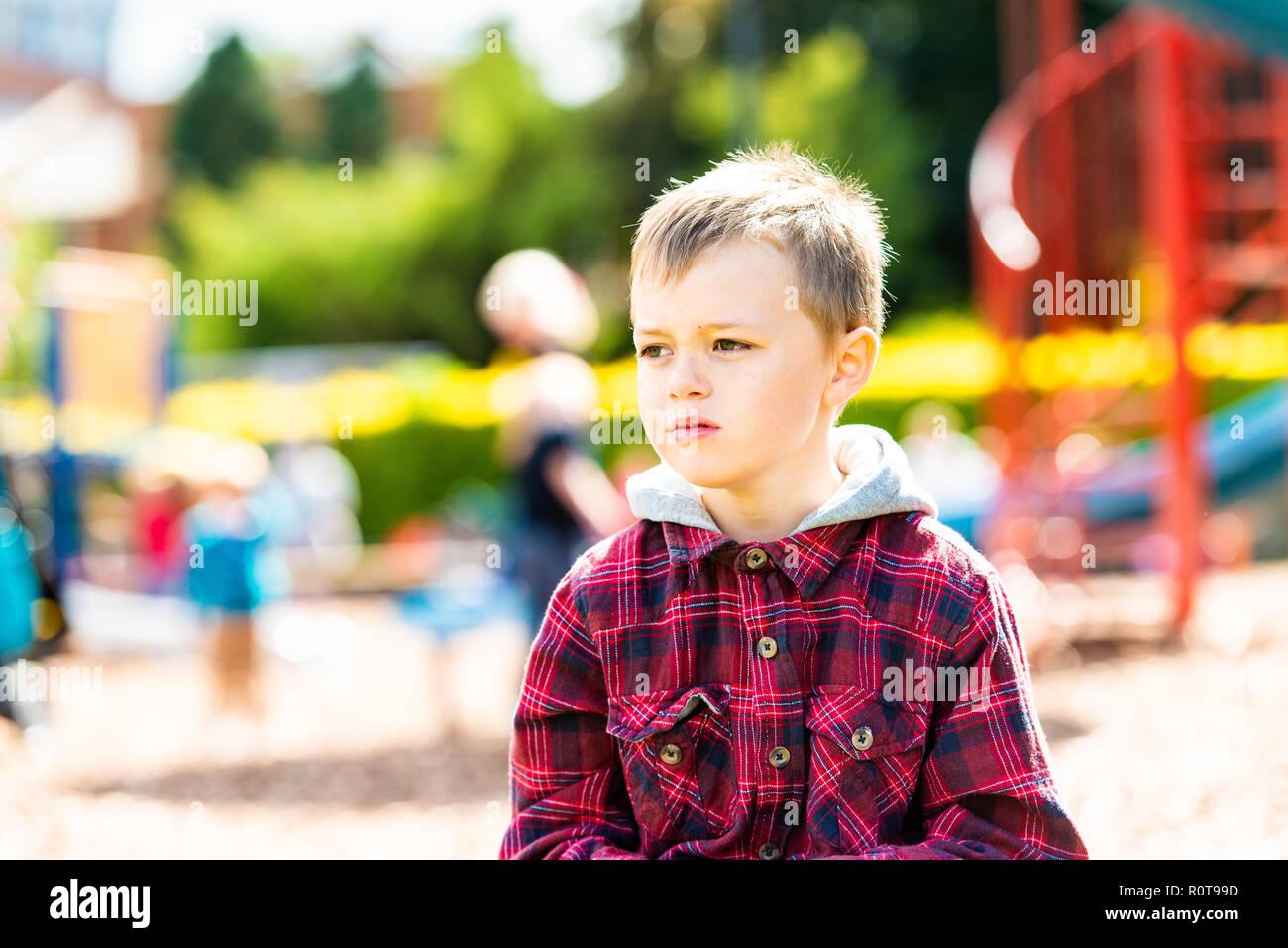 A handsome boy with ADHD, Autism, Asperger Syndrome sitting at the park ...