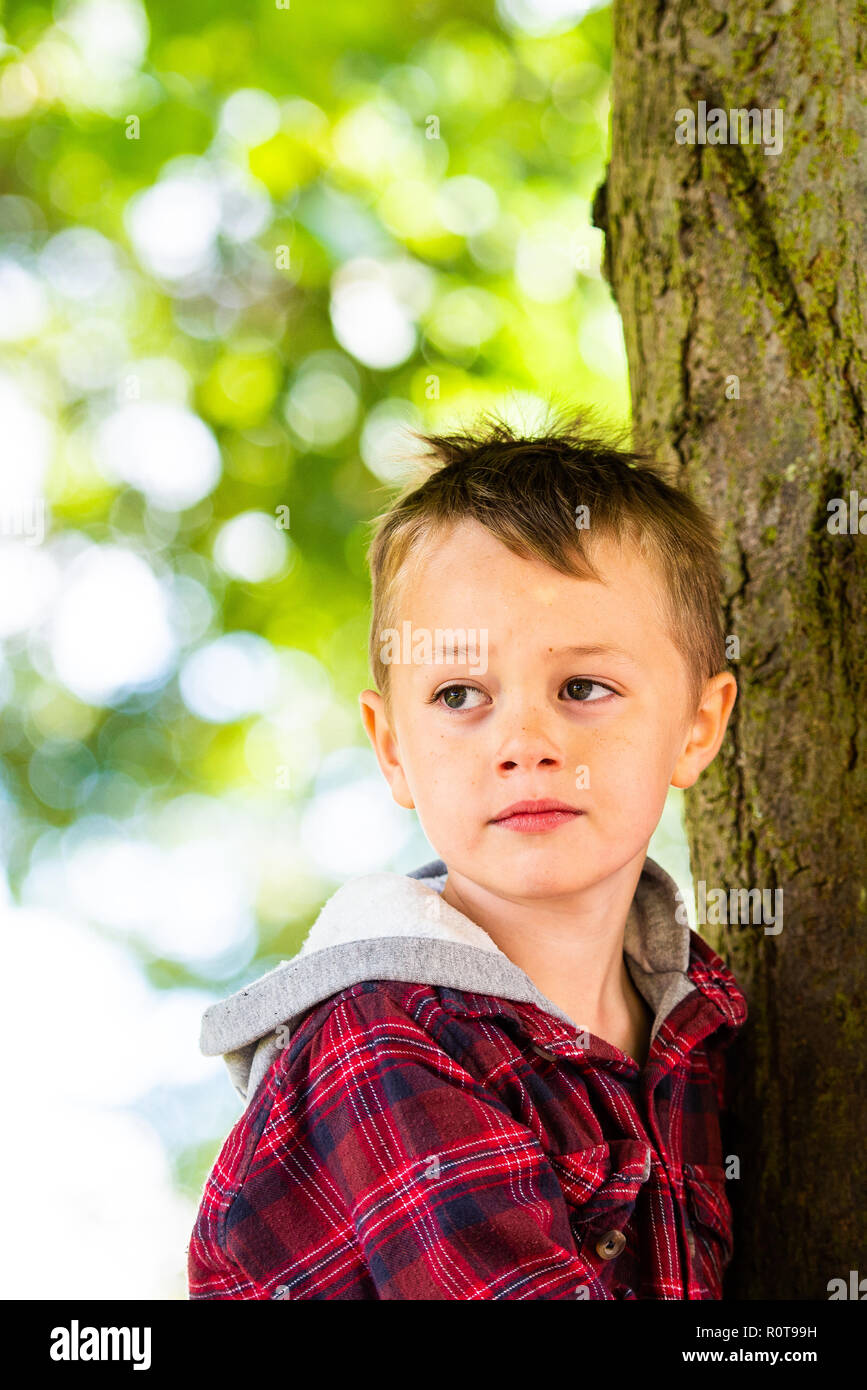 A handsome boy with ADHD, Autism, Asperger Syndrome sitting at the park ...