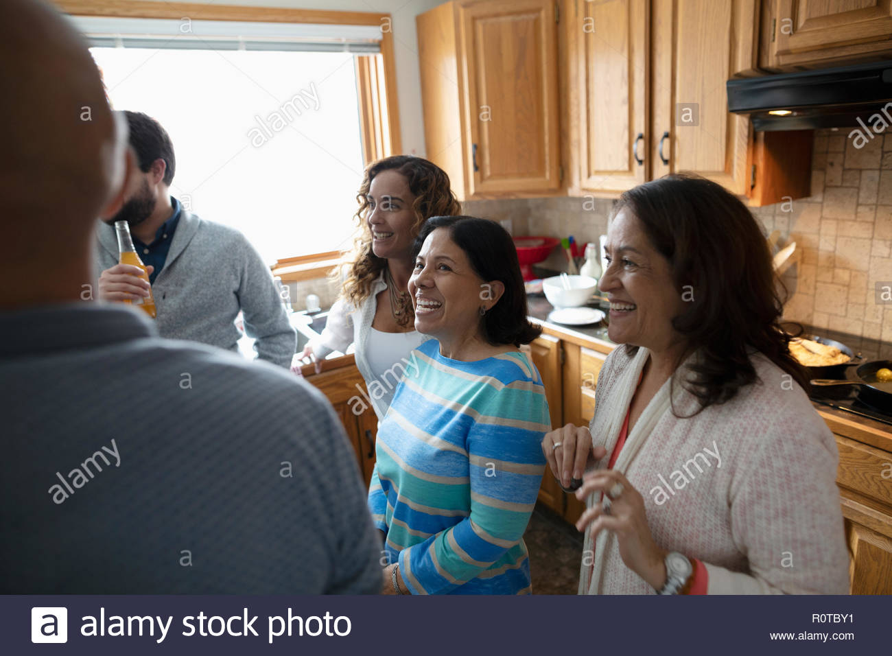 Latinx family talking in kitchen Stock Photo - Alamy
