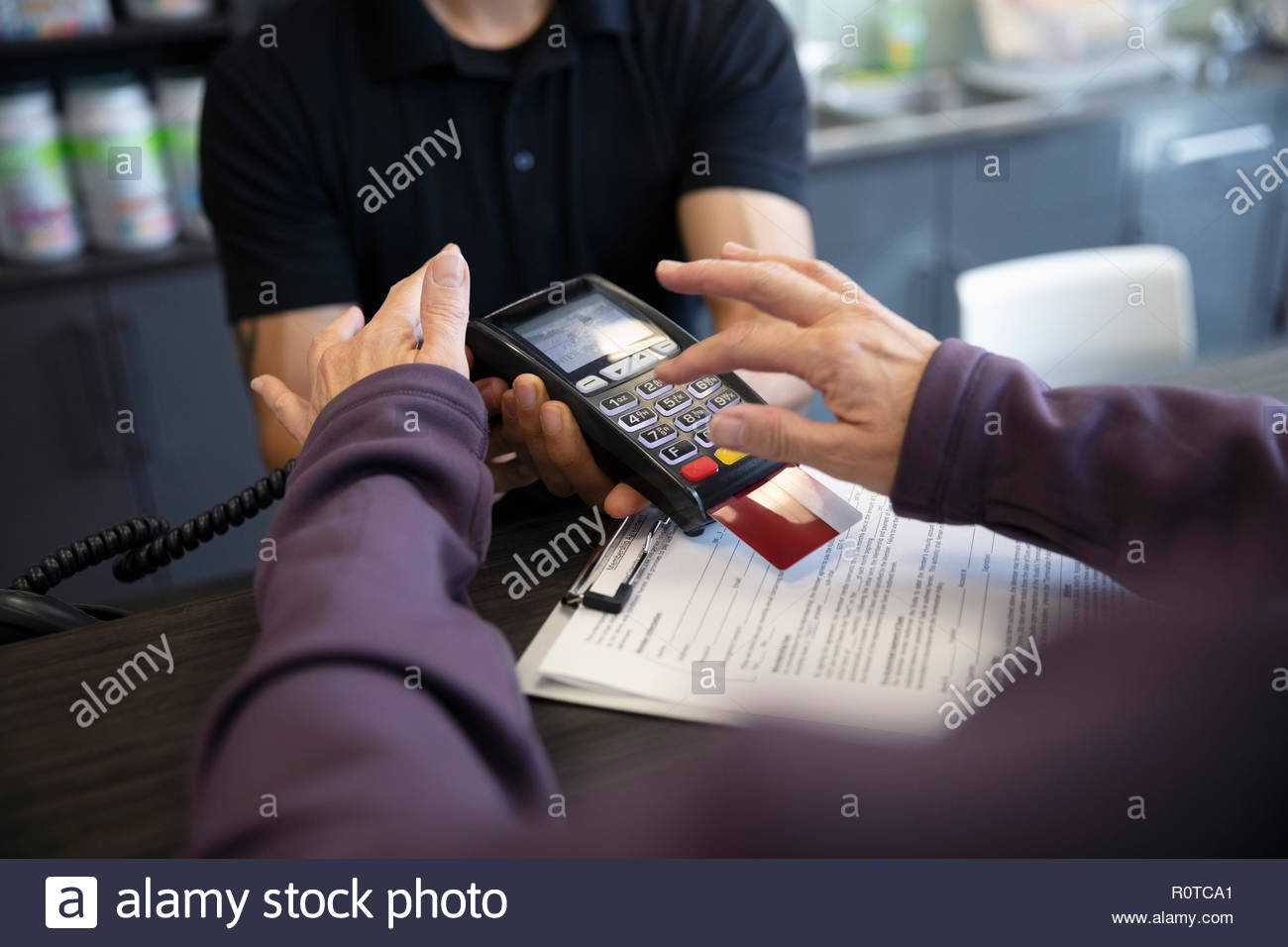 Close up woman paying, using credit card reader at gym front desk Stock ...